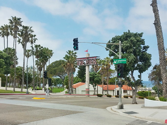 The iconic pier sign stands tall among palm trees, like a friendly greeter saying "Your stress ends here."