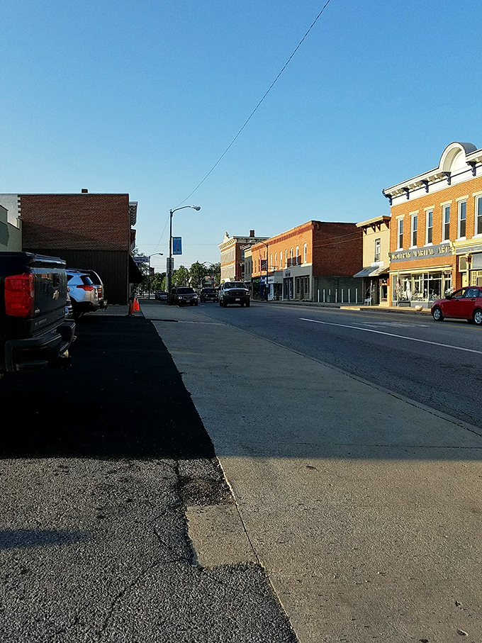 Evening light bathes Main Street in golden hues, transforming ordinary brick into the kind of warm welcome that makes newcomers feel instantly at home.