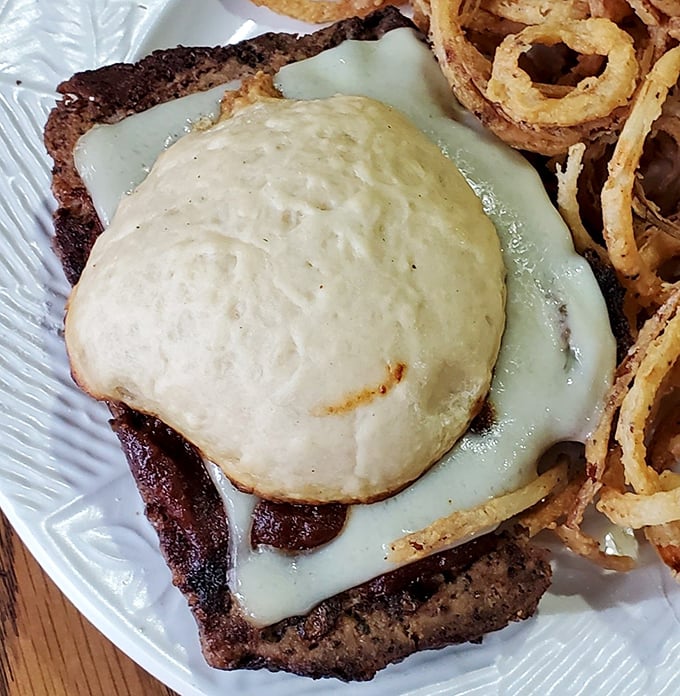 This isn't just a burger&mdash;it's a testament to the power of melted cheese and perfectly seasoned beef. The crispy onion rings are the supporting actors who steal the show.