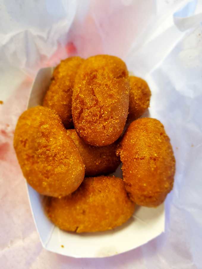 Golden-fried hush puppies that crunch like childhood memories &ndash; crispy outside, tender inside, and worth every single calorie.