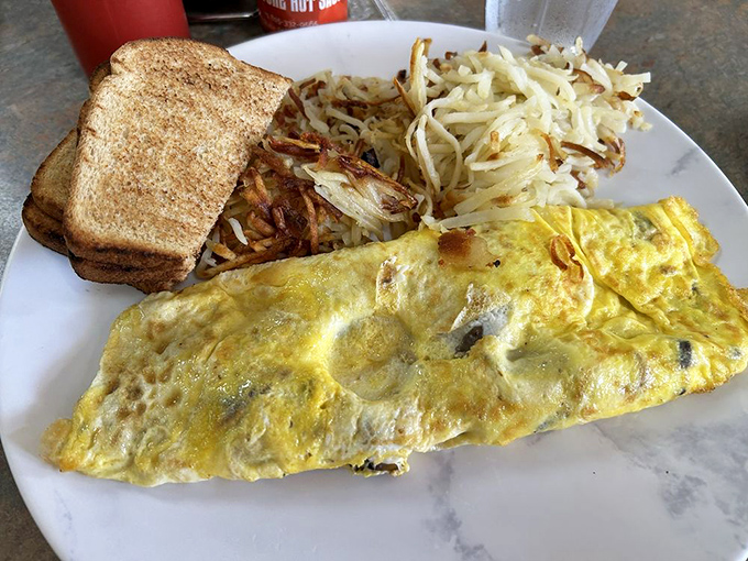An omelet so fluffy it practically hovers above the plate, with toast standing by for the important job of sopping up every last bite.