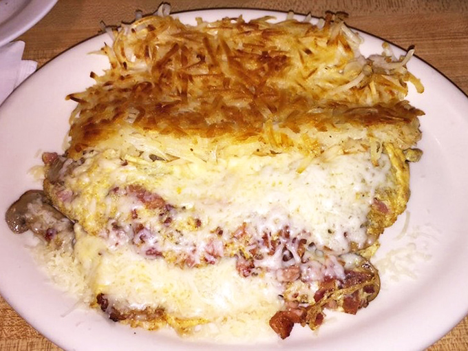 This isn't just an omelet—it's a cheese-blanketed masterpiece with hash browns so perfectly golden they deserve their own Instagram account.