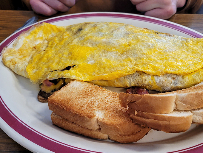 An omelet so perfectly folded it could teach origami classes, paired with toast that's achieved that ideal shade of golden-brown.