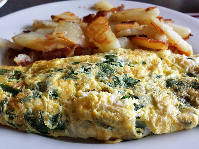 The spinach omelet that launched a thousand brunches &ndash; fluffy eggs folded around vibrant greens, paired with home fries that achieve the perfect crisp-tender balance.