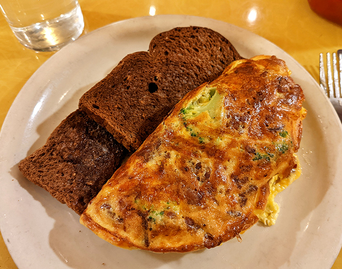 This isn't just an omelet&mdash;it's a perfectly executed egg envelope delivering cheesy, veggie goodness alongside hearty slices of dark toast.