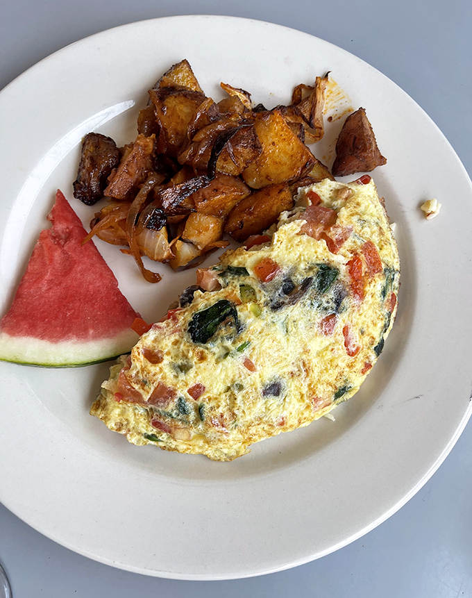 This veggie-packed omelet folded like a yellow canvas painted with colorful peppers and tomatoes proves that healthy can still be indulgent in the right hands.