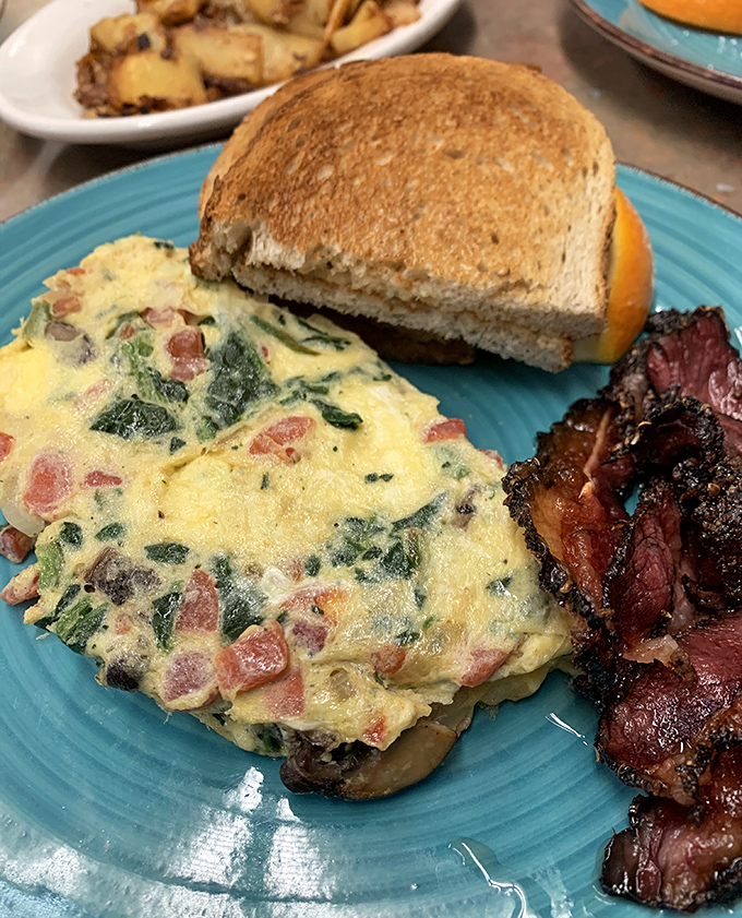 A proper omelet should be a canvas of possibility. This veggie-packed masterpiece alongside crispy bacon makes morning meetings something to look forward to.