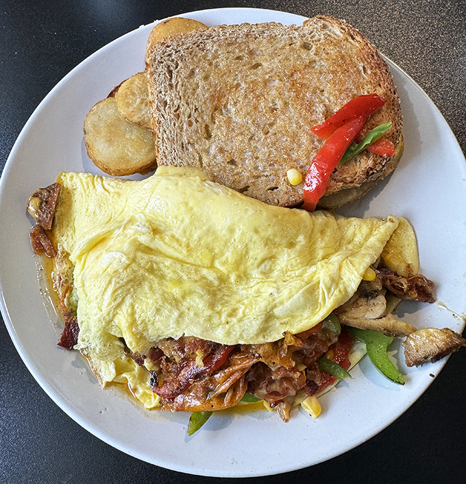 This isn't just an omelet; it's a morning masterpiece with enough fillings to make your regular breakfast feel woefully inadequate.