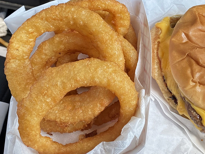Golden onion rings that shatter with each bite sit beside their burger companion &ndash; a dynamic duo that Batman and Robin would envy.