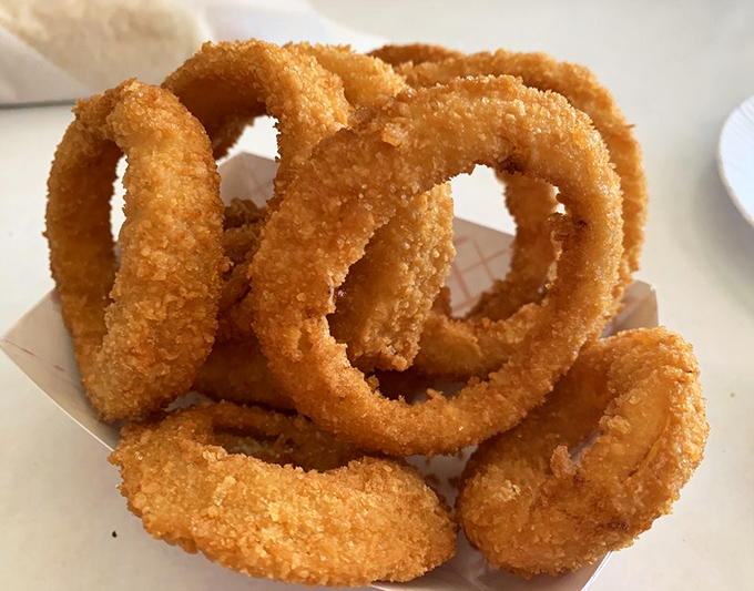 Golden onion rings stacked like delicious jewelry&mdash;crispy, light, and worth every calorie-laden bite.