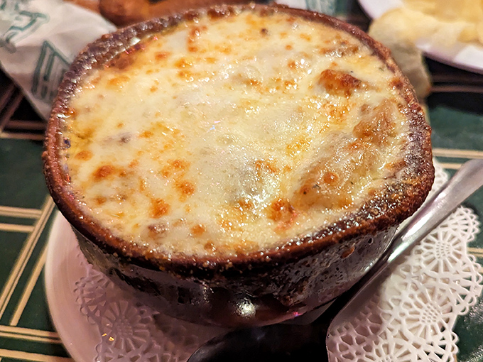 French onion soup bubbling under a blanket of melted cheese &ndash; winter comfort in a ceramic bowl.