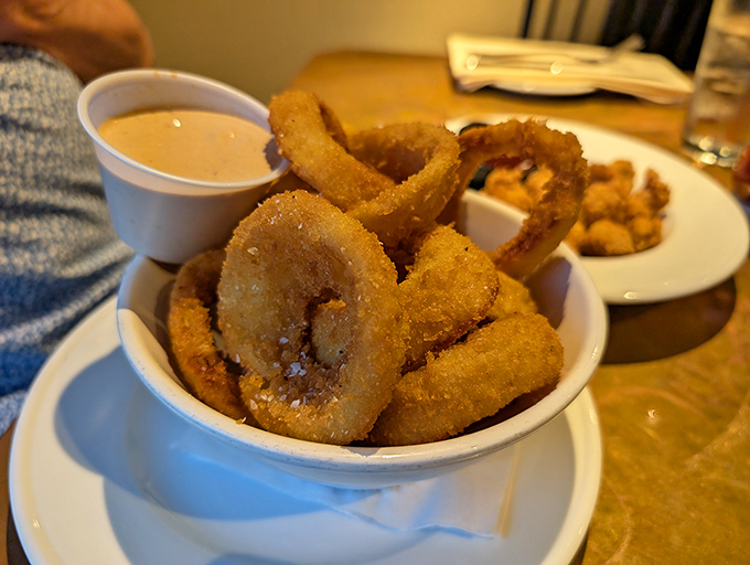 Crispy onion rings stacked like delicious golden halos, ready to be dunked in that creamy dipping sauce.