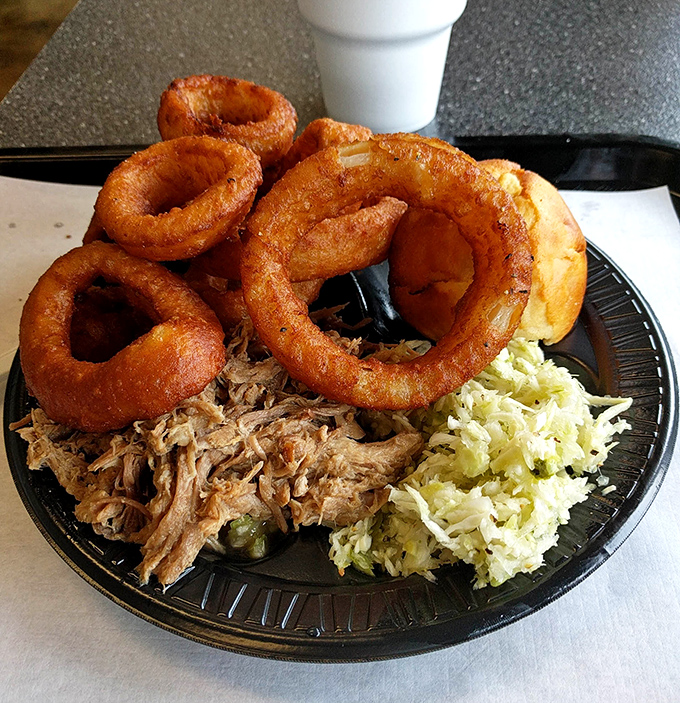 Onion rings that achieve that perfect golden crunch, keeping company with pulled pork and slaw. A plate that hits all the right notes&mdash;smoky, crunchy, tangy, and tender.