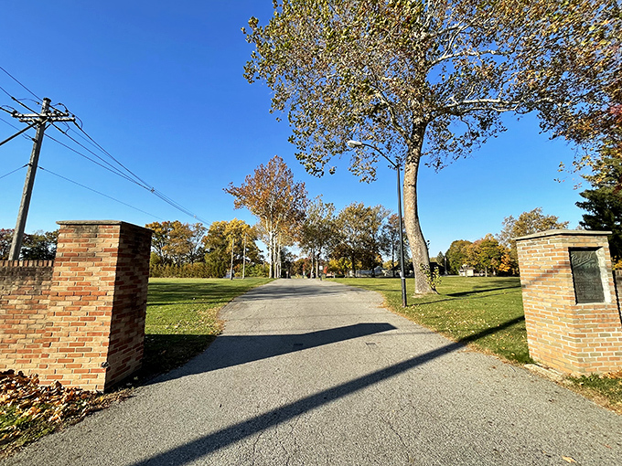 Packard Park's entrance invites visitors through brick pillars that frame nature's canvas, a doorway to tranquility in the midst of city life.