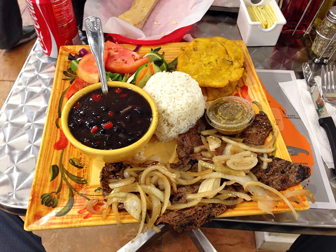 Palomilla steak with all the fixings. Thin-cut beef topped with saut&eacute;ed onions, served alongside beans darker than midnight and rice whiter than South Beach sand.