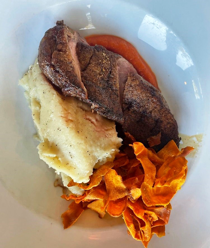 This duck breast, perfectly seared and paired with creamy potatoes and crispy vegetable chips, is the kind of dish that silences conversation at the table.