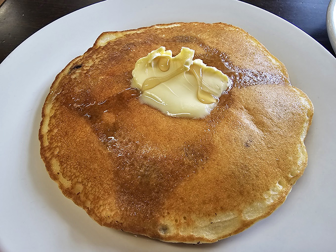 Behold the pancake in its natural habitat&mdash;golden, fluffy, and adorned with a melting pat of butter that's creating its own little syrup river.