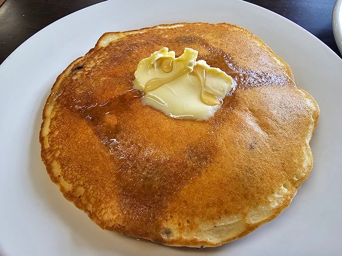 Behold the pancake in its natural habitat&mdash;golden, fluffy, and adorned with a melting pat of butter that's creating its own little syrup river.