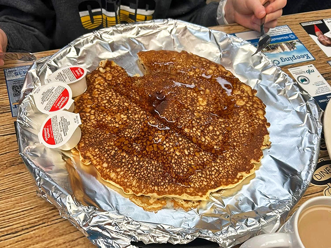 These pancakes aren't just big; they're election-promise big, stretching across the plate with maple syrup pooling in their nooks and crannies.