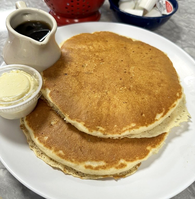 Pancakes so perfectly golden they belong in Fort Knox. The butter melting into those fluffy stacks is performing a delicious disappearing act.
