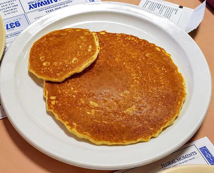 Golden pancakes so perfectly round and fluffy, they could moonlight as edible flying saucers from breakfast heaven above.
