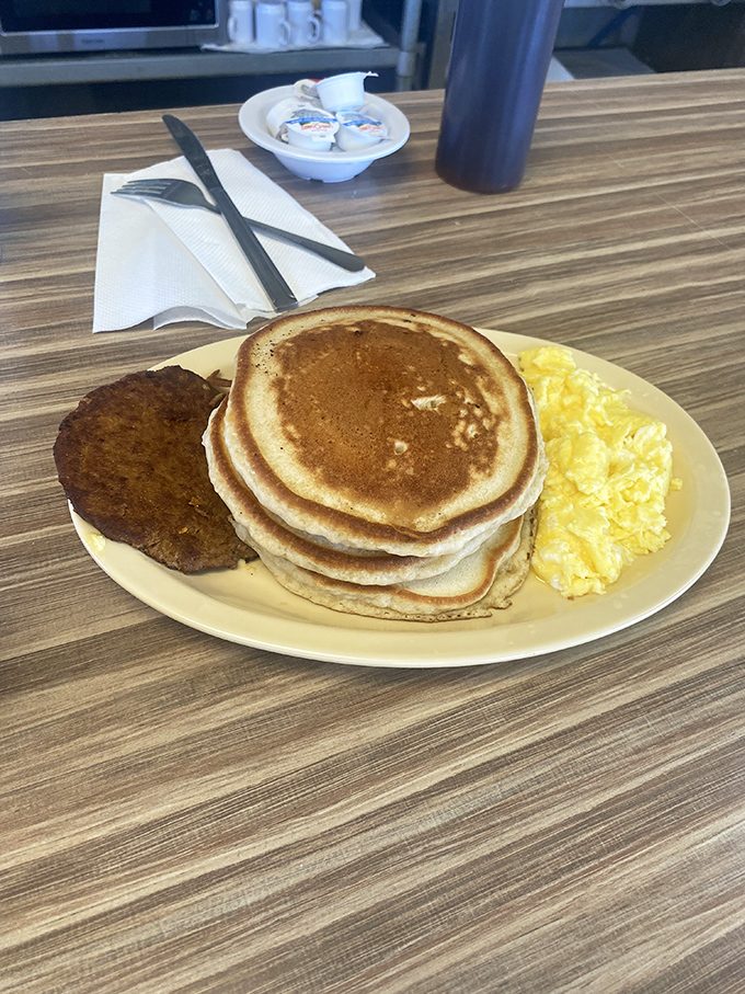Stack attack! These golden-brown pancakes with a side of sausage and eggs are the breakfast equivalent of hitting the culinary jackpot.