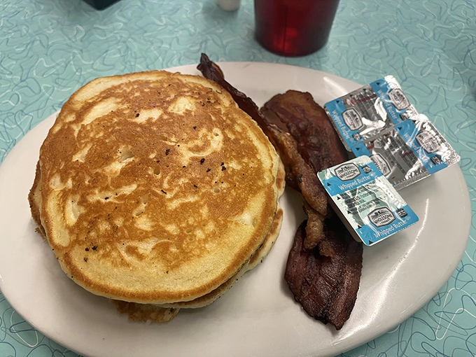Pancakes so perfectly golden they could win medals, paired with bacon that's achieved that mythical balance between crisp and chewy.