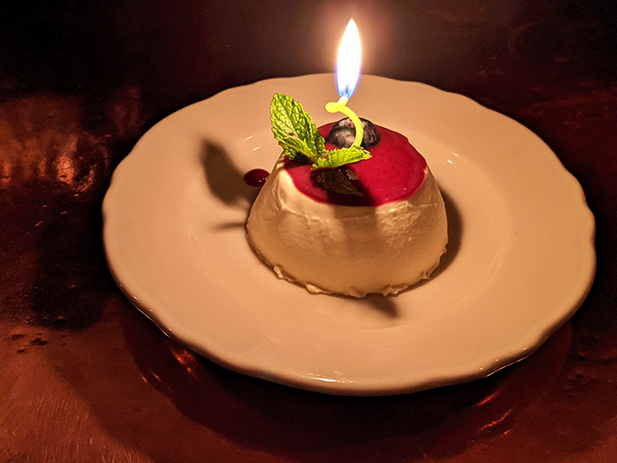 A panna cotta with berry topping and a birthday candle&mdash;dessert that says "celebration" without shouting it from the rooftops.
