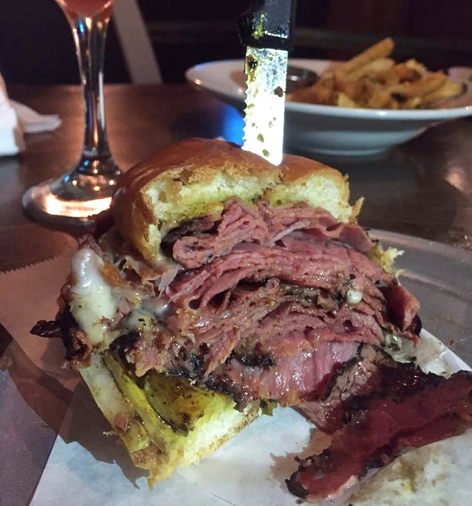Half-eaten pastrami sandwich reveals the generous portions inside. This isn't a photo op—it's a commitment to excellence.
