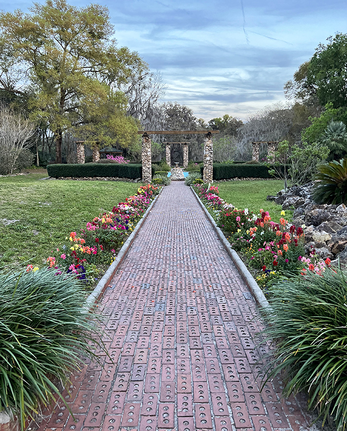 A brick path lined with colorful blooms leads to stone ruins. It's like someone transplanted an English garden into Florida's subtropical playground.