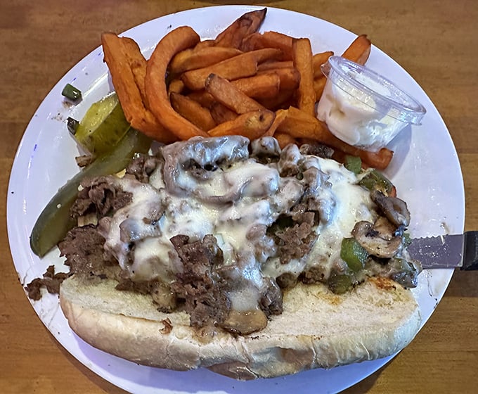 Behold the Philly cheesesteak in its natural habitat&mdash;smothered in mushrooms and melty cheese. The sweet potato fries alongside are no mere sidekick.