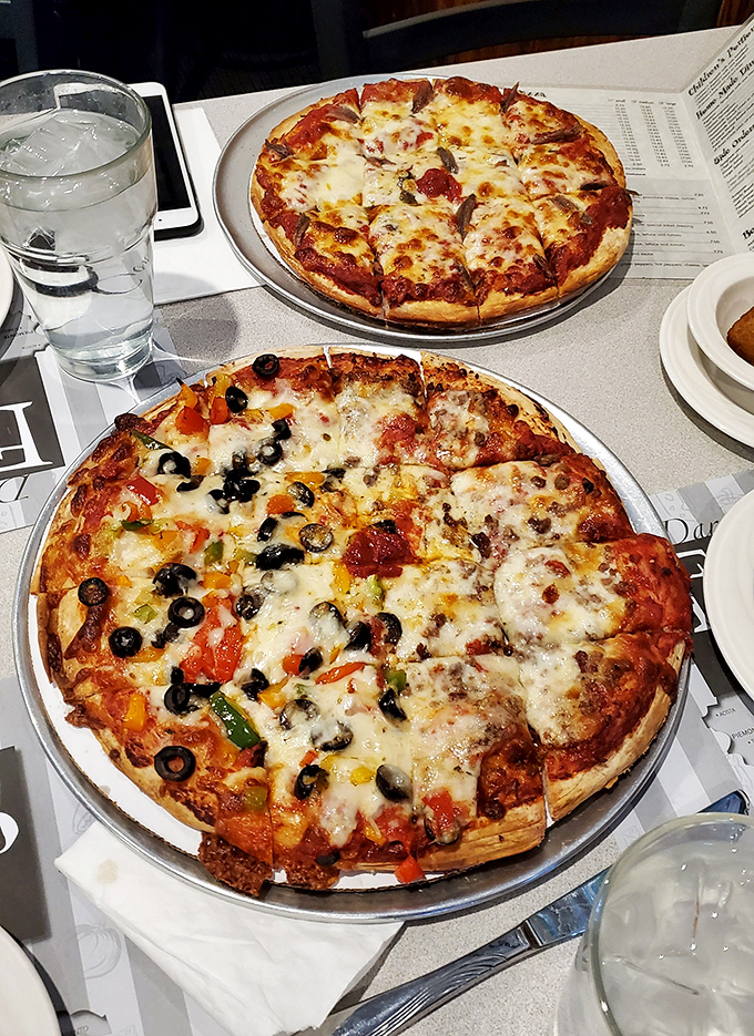 Pizza perfection comes in pairs! The supreme on the bottom is playing the "more is more" game, while its cheese counterpart above proves simplicity has its own superpower.