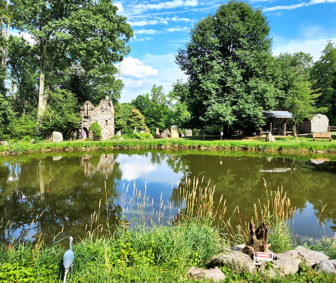Reflections double the beauty at Columcille's serene pond. Stone structures and lush greenery create a postcard-perfect scene that calms the soul instantly.