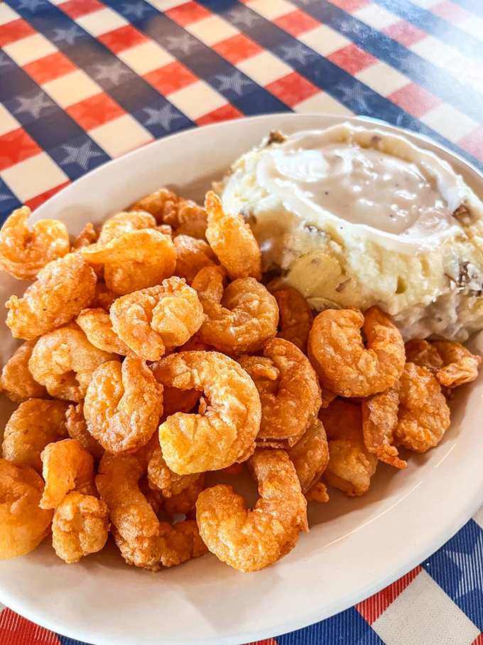 A mountain of golden popcorn shrimp alongside creamy mashed potatoes&mdash;proof that sometimes the best things in life come in small, crispy packages.