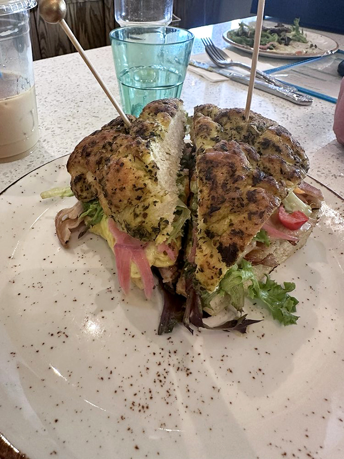 This sandwich isn't just assembled—it's architected, with layers of flavor between herb-flecked biscuits that deserve their own Food Network special.