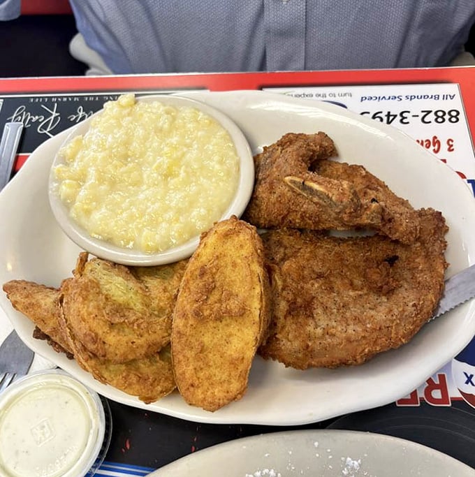 Southern cooking at its finest: a perfectly seasoned pork chop sharing the spotlight with creamed corn and fried squash. Your grandmother would approve.
