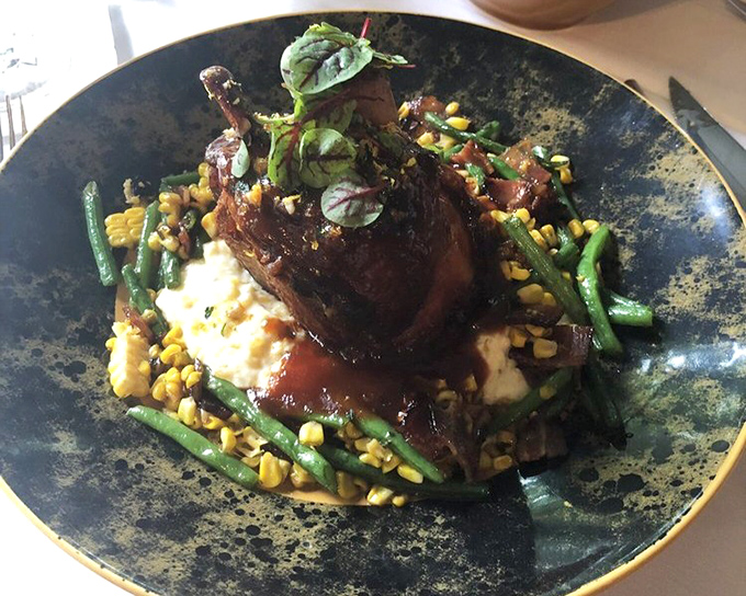 The pork shank perches majestically atop creamy grits and colorful vegetables, like a meaty monument to Pennsylvania's farming heritage that demands your respect.