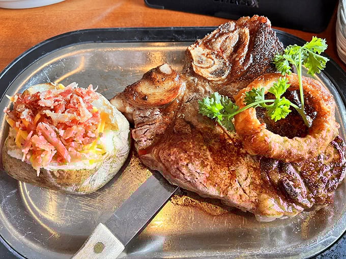 The porterhouse arrives like a carnivore's dream, complete with loaded baked potato. This isn't dinner; it's a commitment to excellence that requires a strategy.