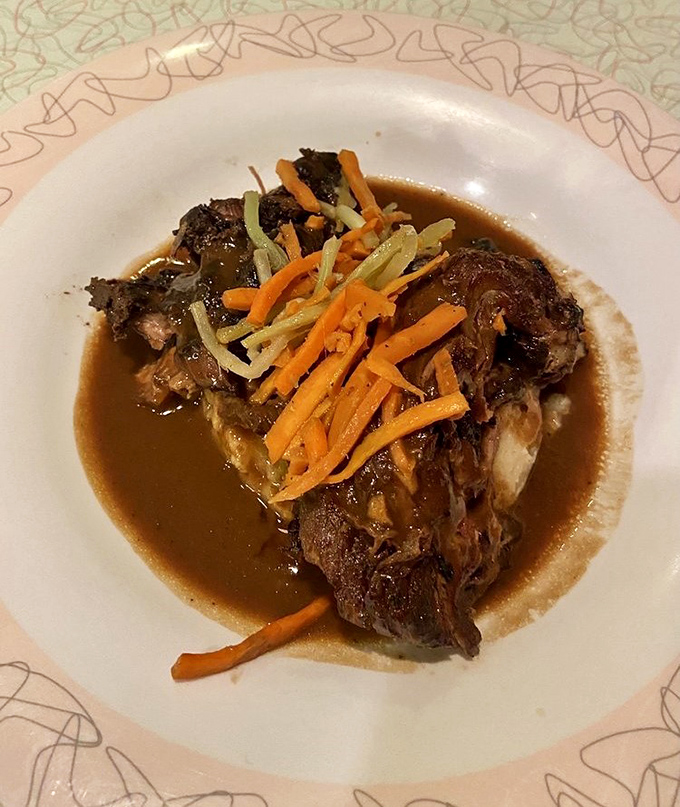 The pot roast arrives like a celebrity, garnished with carrots and celery that spent hours getting to know each other in a slow-cooker love story.