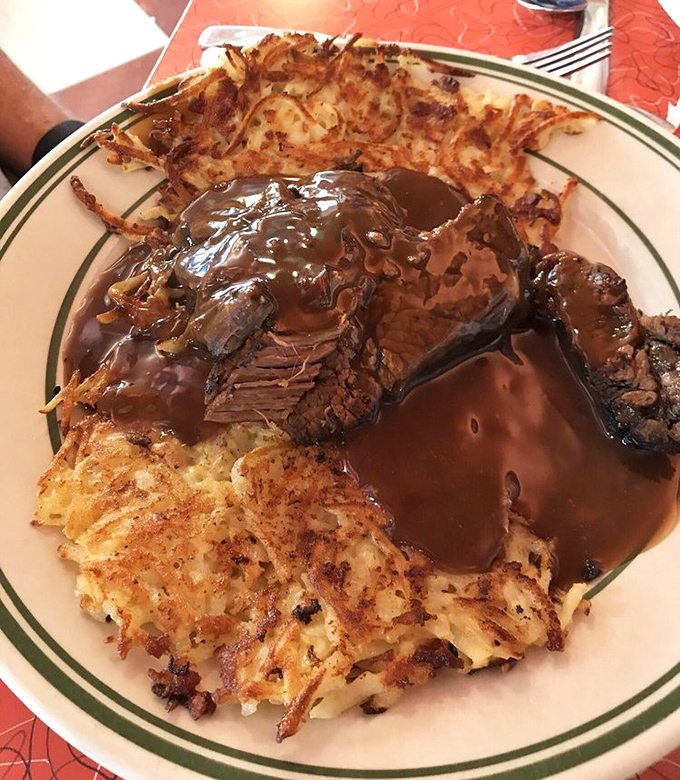 Pot roast so tender it practically surrenders to your fork, surrounded by hash browns that have achieved the perfect crisp-to-fluffy ratio.