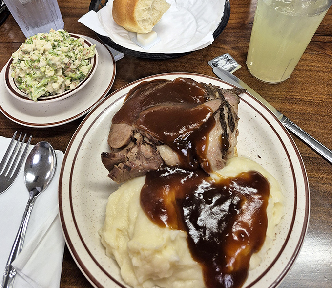 Pot roast that surrenders at the mere suggestion of a fork, alongside mashed potatoes standing by to soak up that glossy, soul-satisfying gravy.