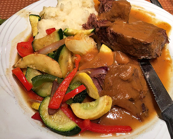 Pot roast so tender it practically surrenders to your fork. The gravy alone could make a vegetarian reconsider their life choices.