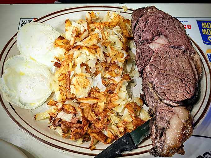 The holy trinity of diner perfection: prime rib cooked to pink perfection, eggs with sunset-yellow yolks, and hash browns crisped to golden glory.