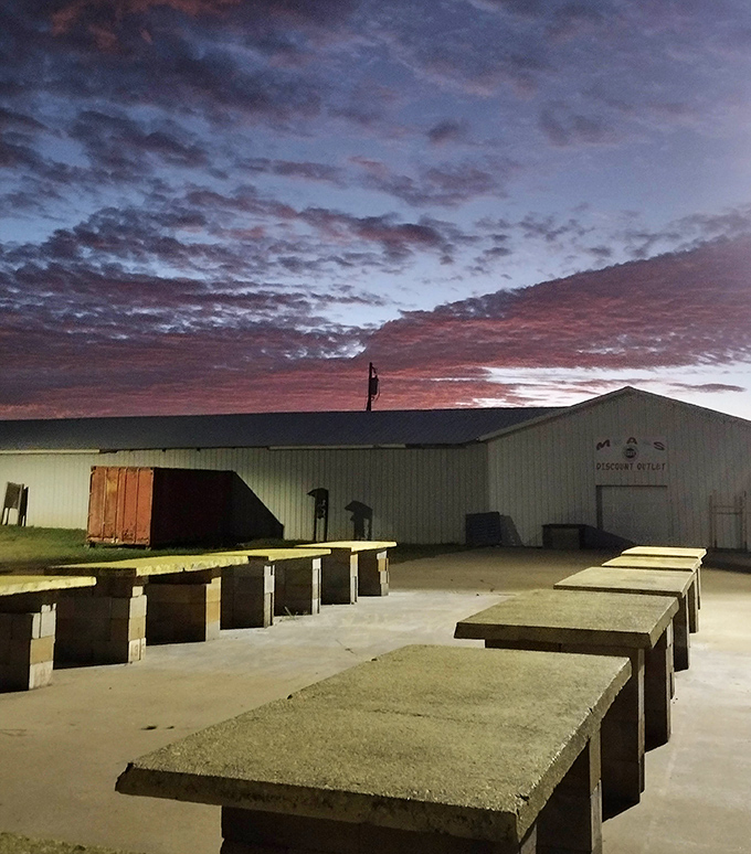 Dawn breaks over the empty vendor tables, a calm before the weekend storm of shoppers, sellers, and storytellers fills this concrete canvas.