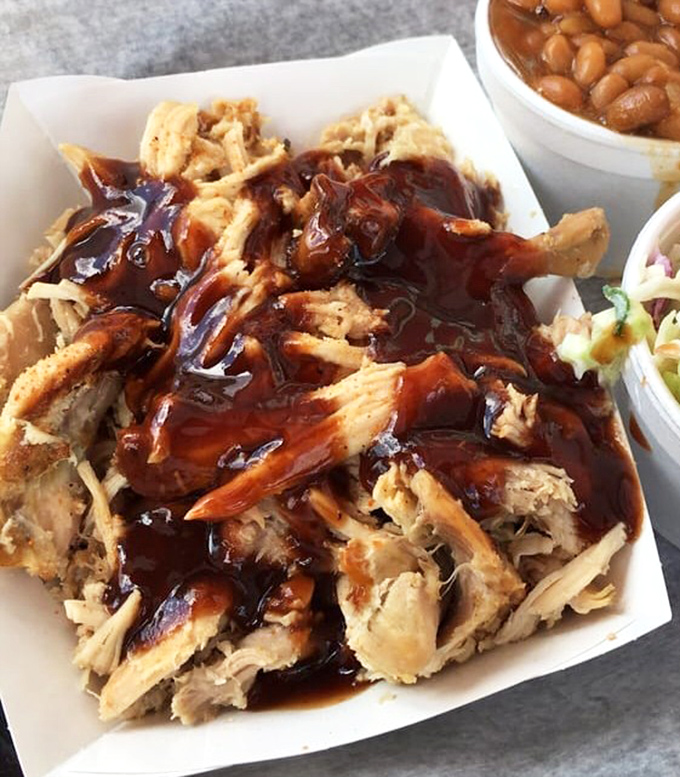 Pulled chicken bathed in sauce that glistens like liquid ruby, making you question why anyone would ever eat poultry prepared any other way.