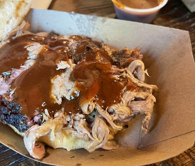 Pulled pork sandwich that's had a proper saucy baptism. The bread's only purpose: to deliver this smoky treasure to your face.