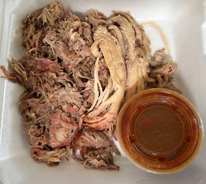 Pulled pork that's been coaxed into surrender after hours in the smoker, ready to be enjoyed with or without sauce&mdash;though that sauce is liquid gold.