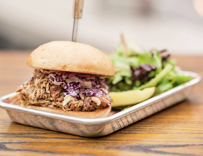 This pulled pork sandwich towers like edible architecture, promising flavors that'll make you forget every other sandwich exists.