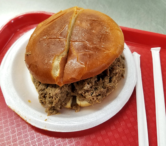 This pulled pork sandwich isn't messing around. The glossy bun barely containing its smoky, savory treasure within.