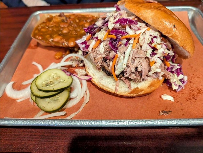 This pulled pork sandwich with vibrant slaw and pickles isn't just lunch&mdash;it's a commitment to excellence that rewards your taste buds handsomely.